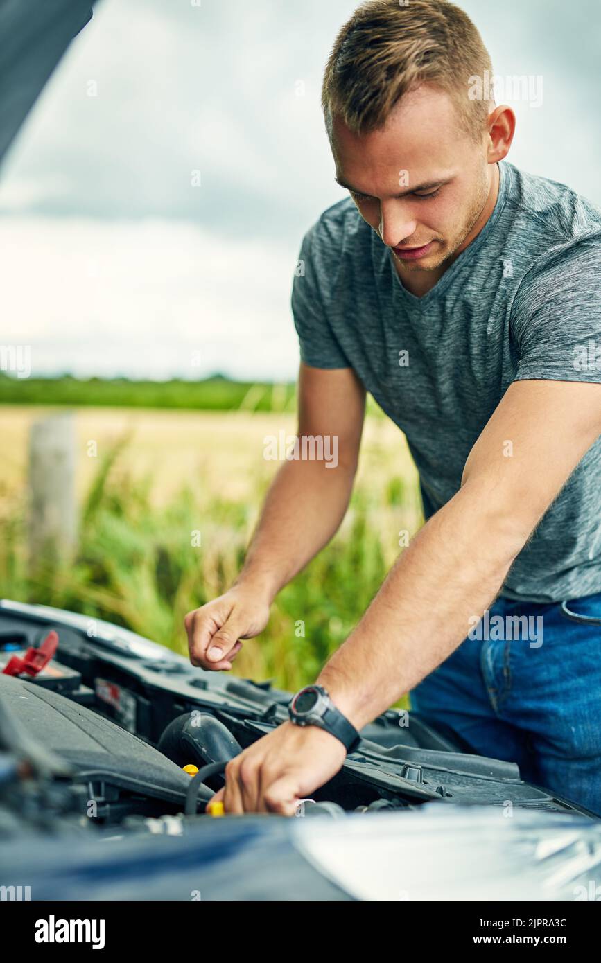Maybe its the oil. a young man checking under the hood of his car after breaking down on the ...