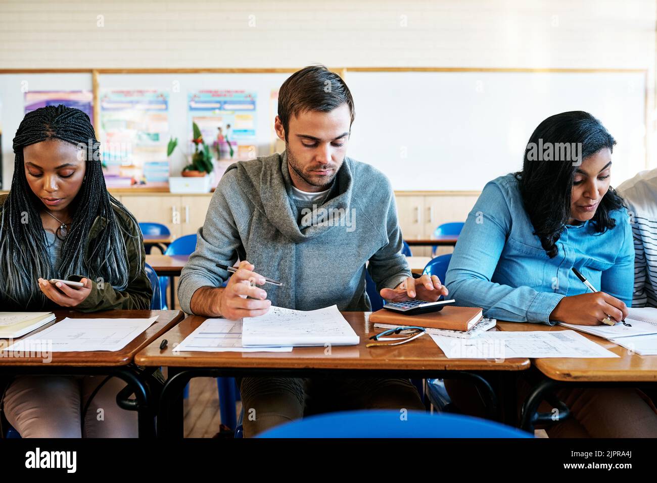 Focused on their studies. a group of young university students working ...