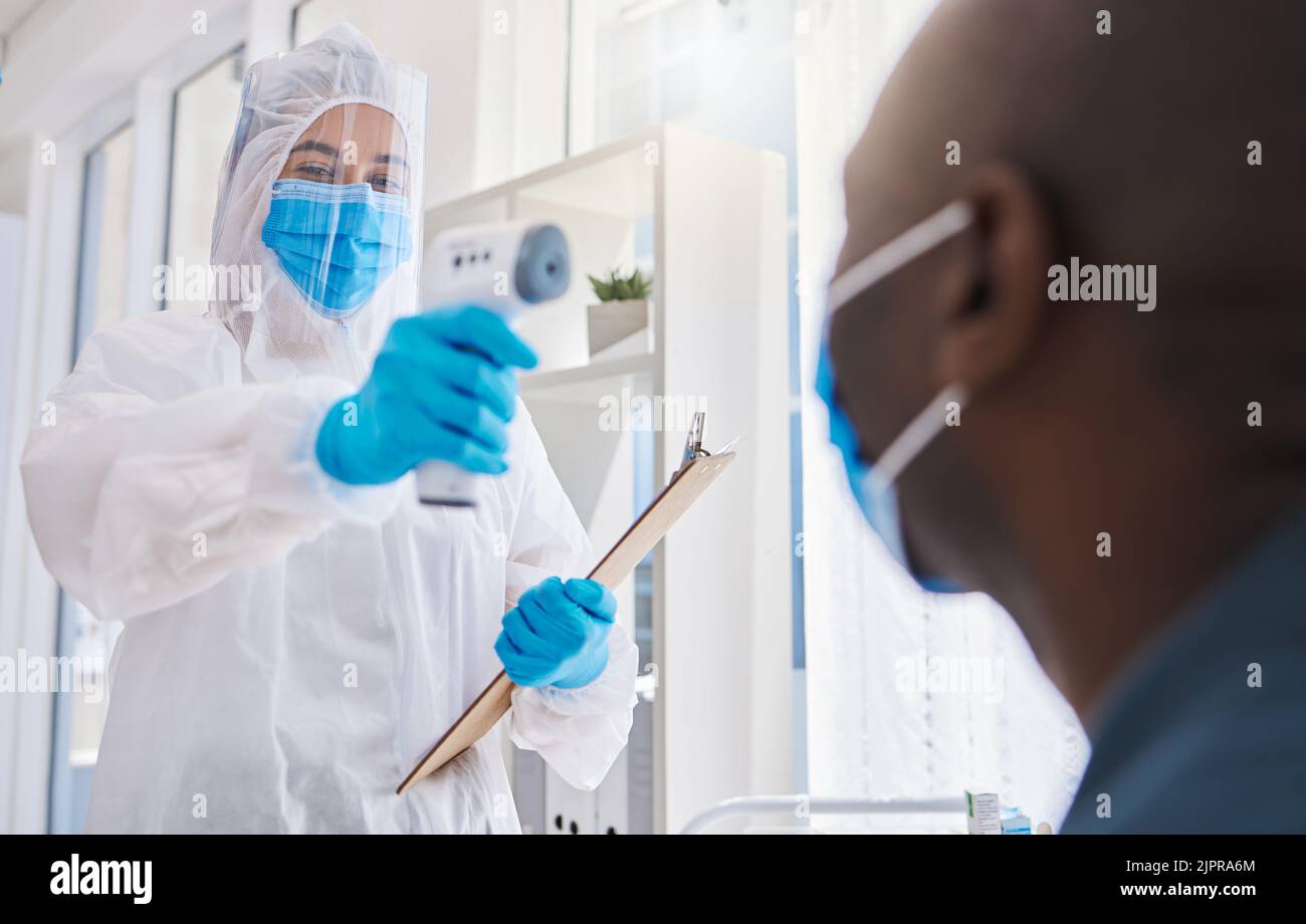 Healthcare worker, checking the temperature of male covid patient for ...