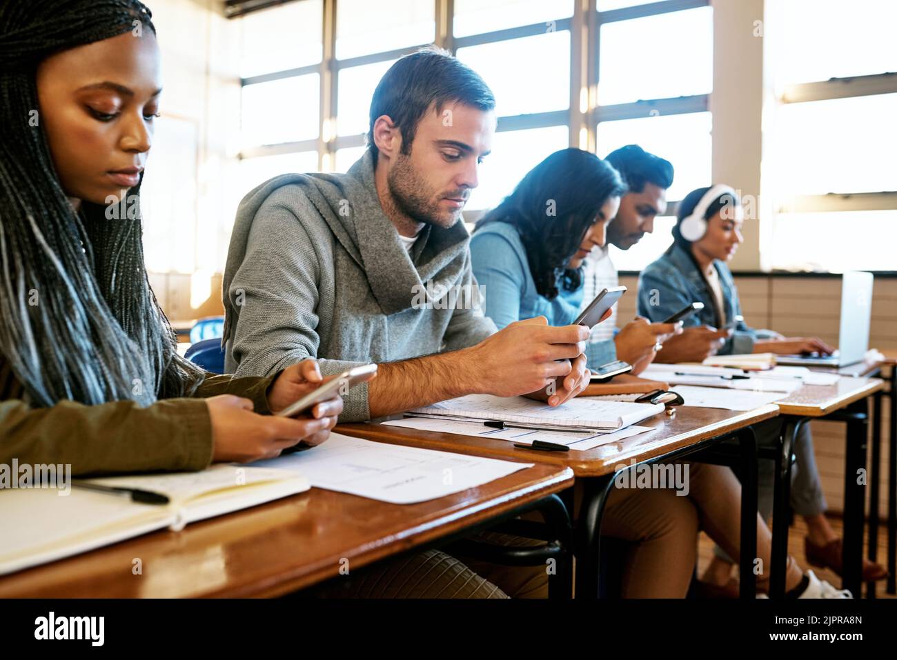 Paying more attention to their phones than to their studies. a group of ...