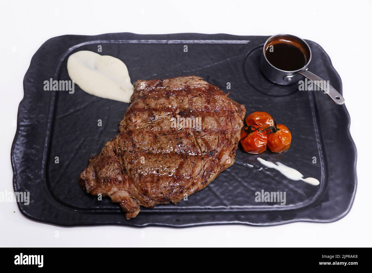 grilled prime ribeye steak with tomato, potato puree and pepper corn ...