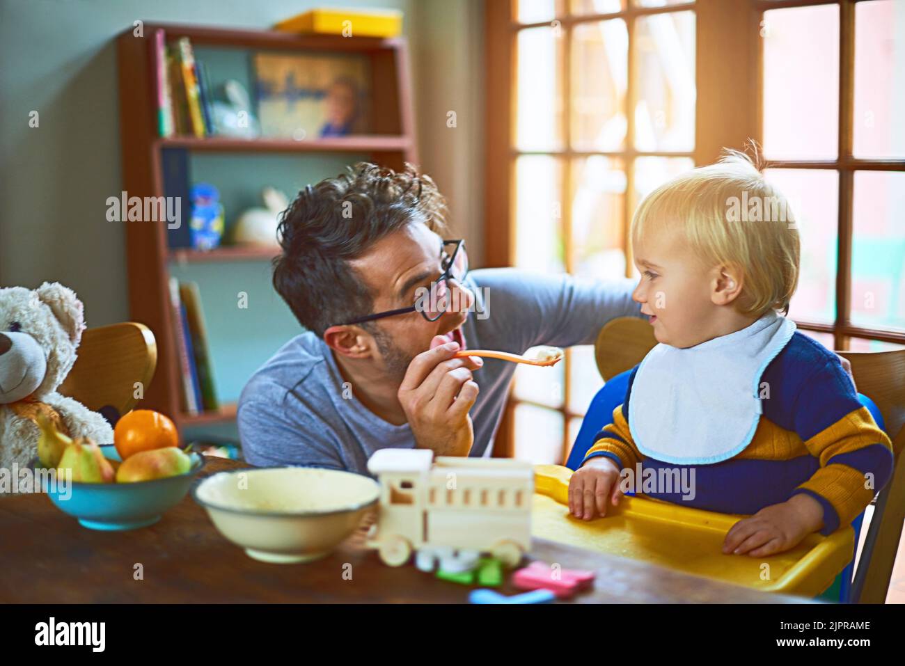 Dad always makes food time fun. a single father feeding his son at home ... Dad always makes food time fun. a single father feeding his son at home ...