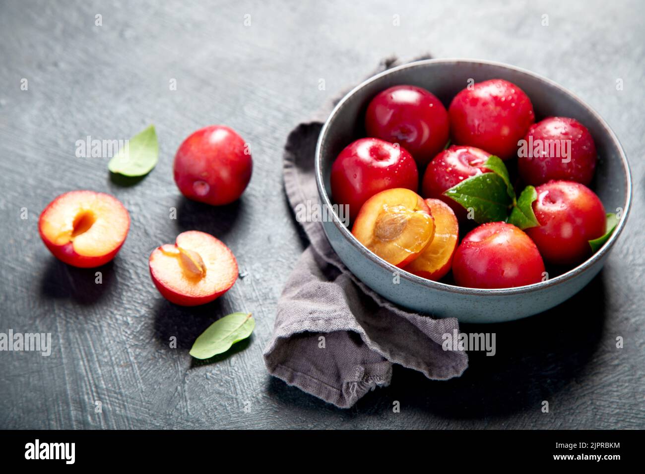 Red plums isolated on dark background. Top view Stock Photo - Alamy