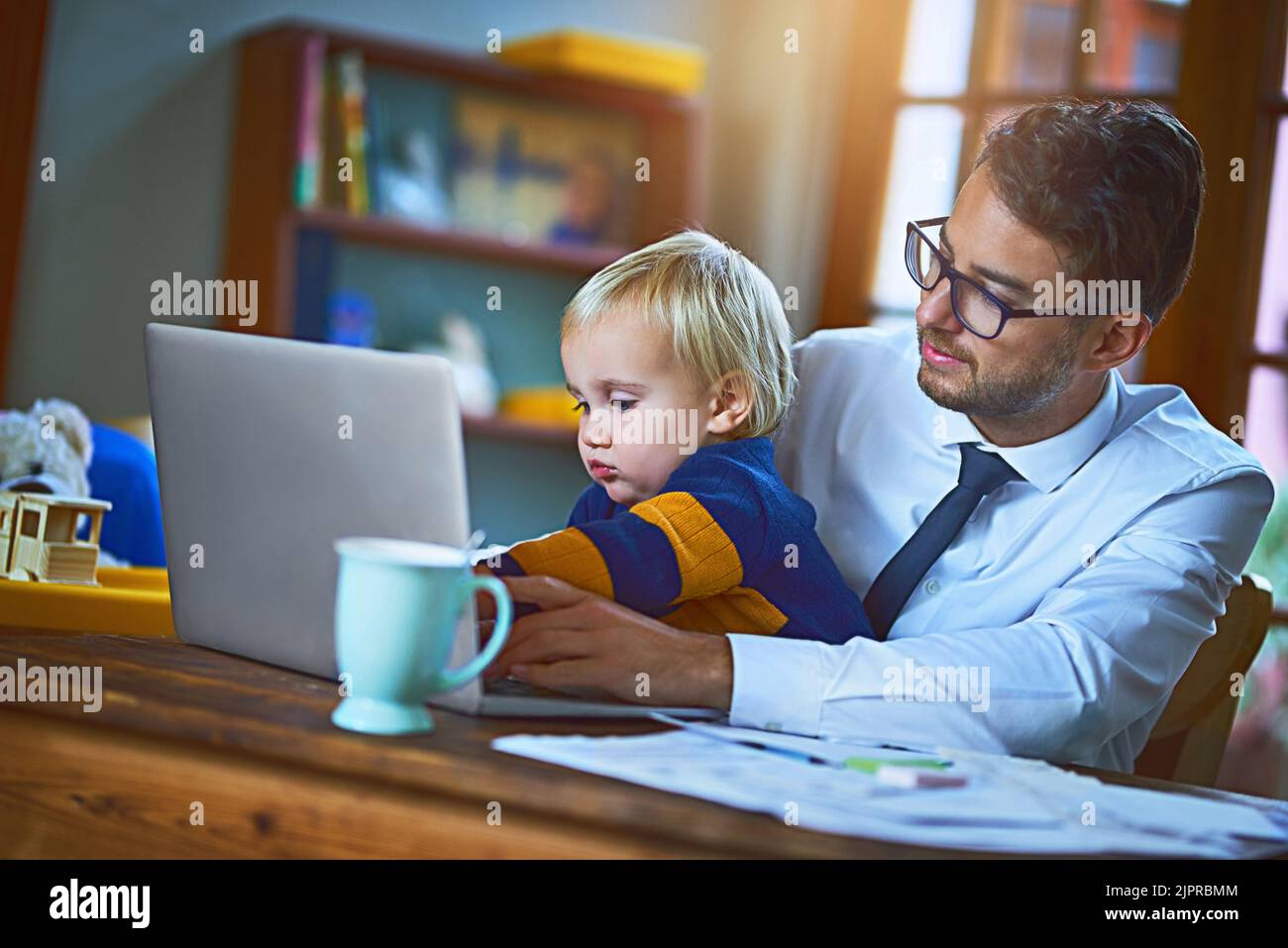 Helping Daddy with his work. a single father and his son using a laptop ...