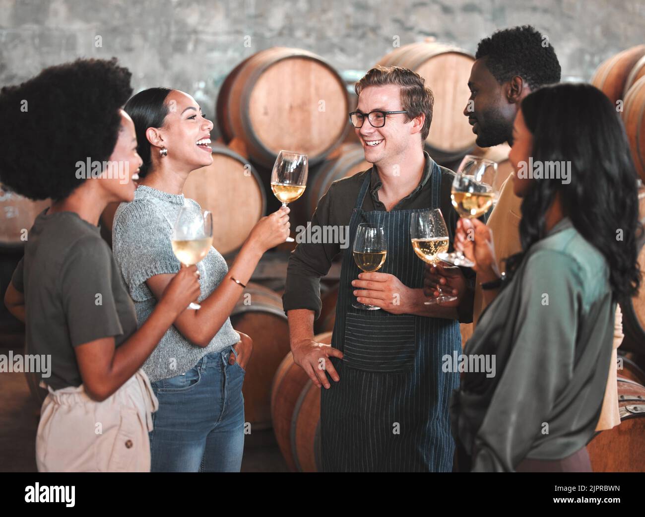 Group of friends wine tasting at a distillery or cellar drinking ...