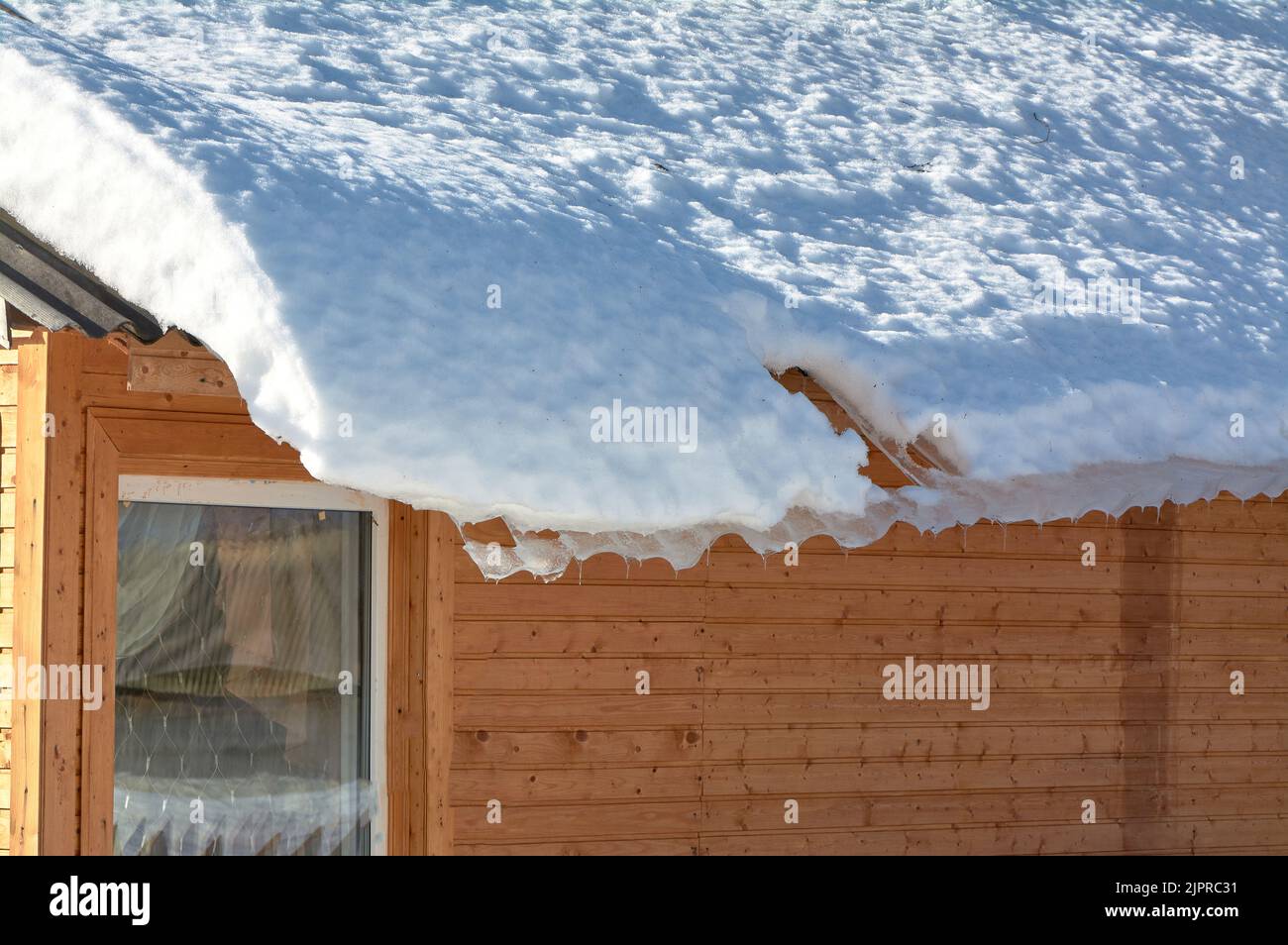 a block of ice hangs from the roof of the house Stock Photo - Alamy