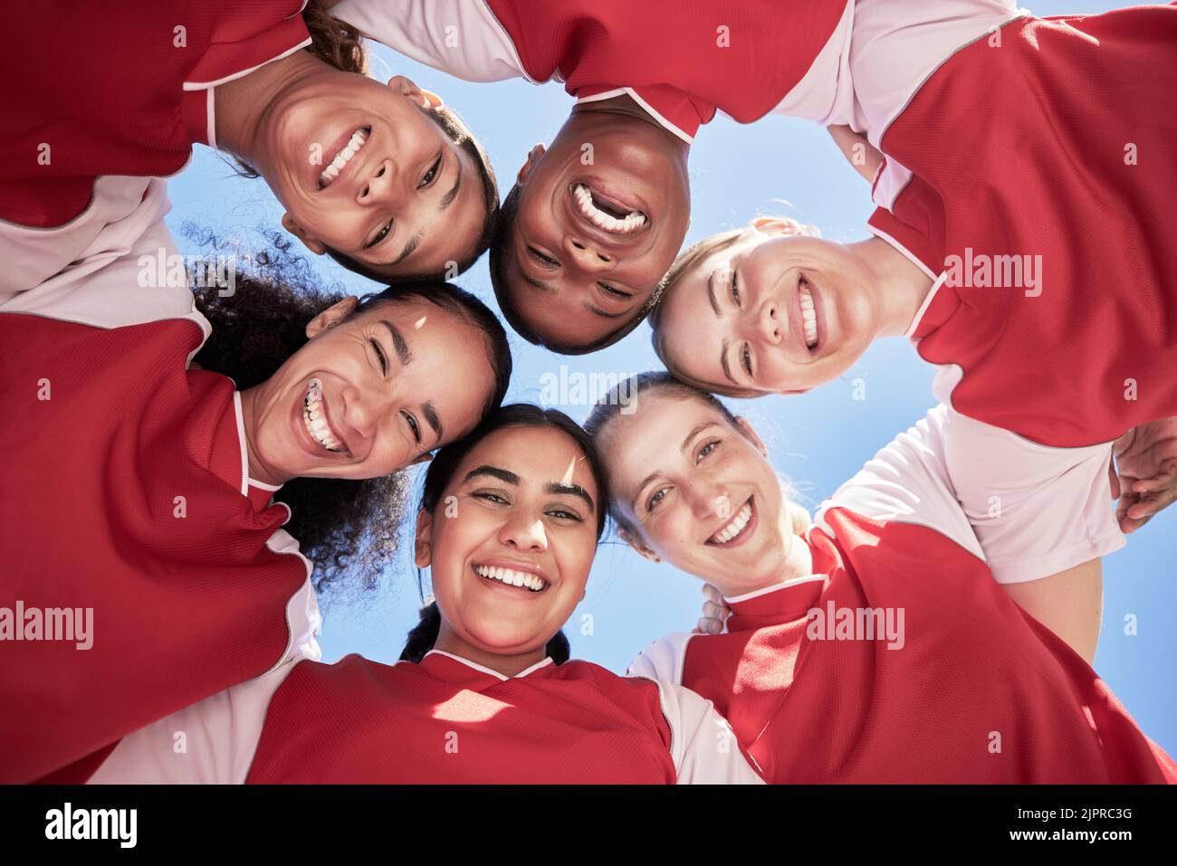 Female soccer team in a huddle smiling in unity and support in a circle ...