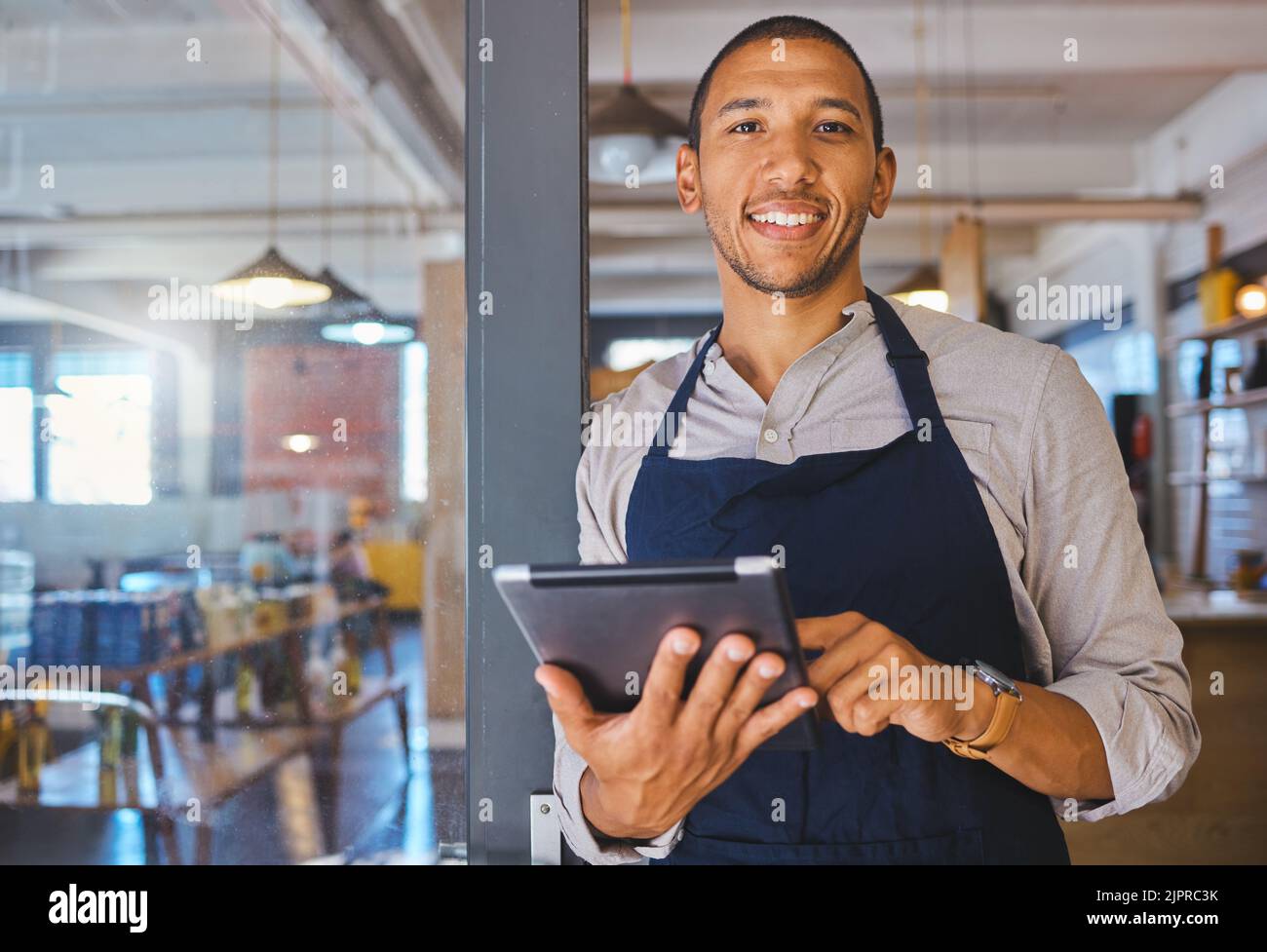 Restaurant entrepreneur with tablet, leaning on door and open to ...