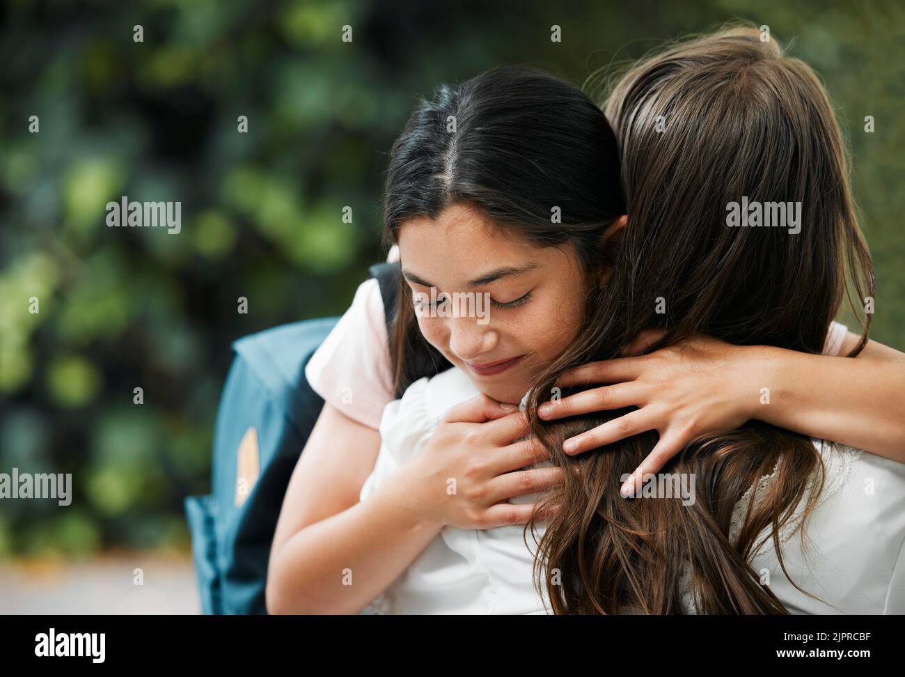 Family hugging on first day of school, mother greeting girl and giving ...
