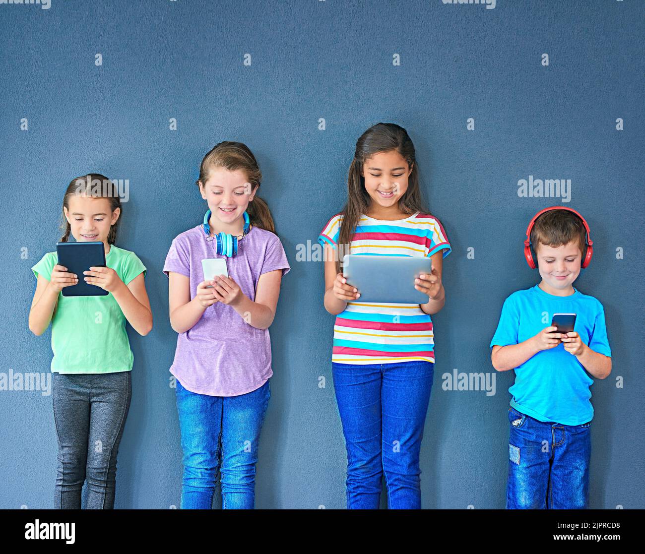 More mobile than ever. Studio shot of a group of kids using wireless ...