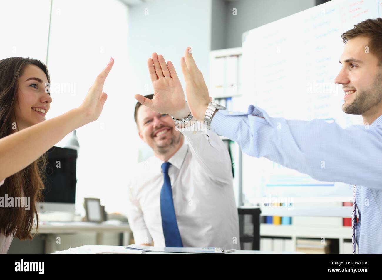Overjoyed team of employees gives five celebrating success Stock Photo ...