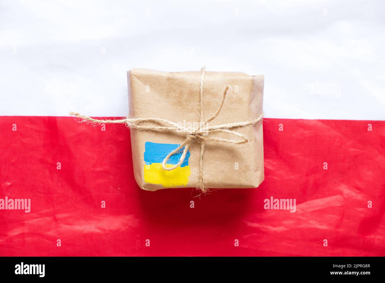 A paper box with a painted flag of Ukraine lies on the flags of Poland ...