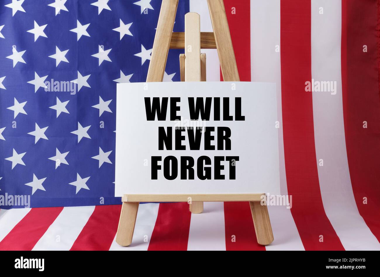 The flag of the United States has a sign that says - We will never ...