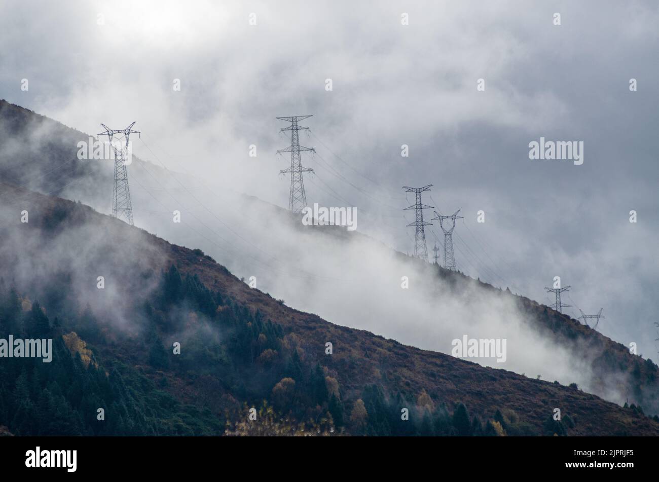 The high voltage transmission towers covered in fog Stock Photo - Alamy