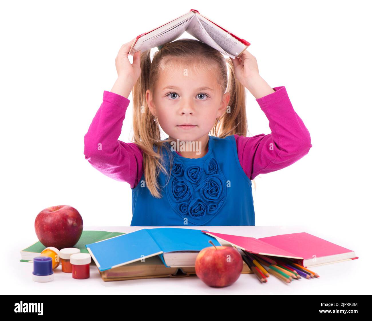 Little smart girl holding a book and reading it, on a white background ...