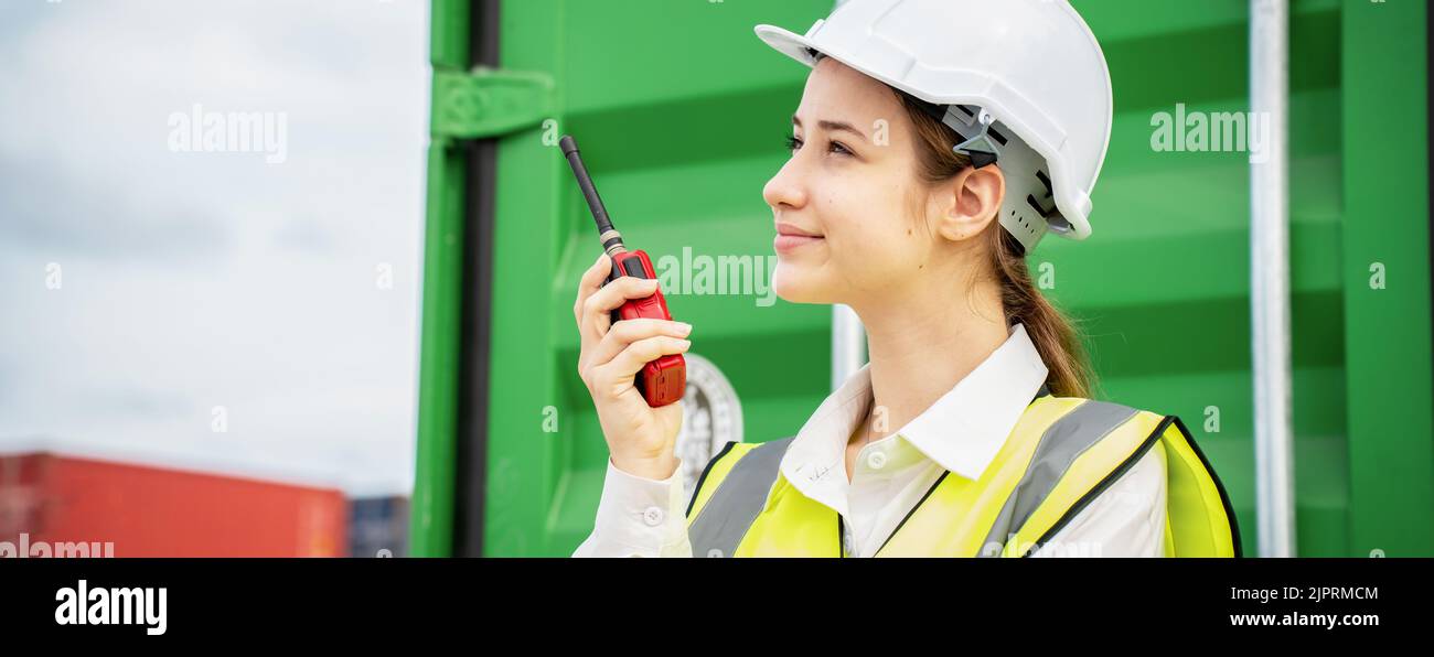 Female Foreman stay in front of container cargo using walkie talkie for ...