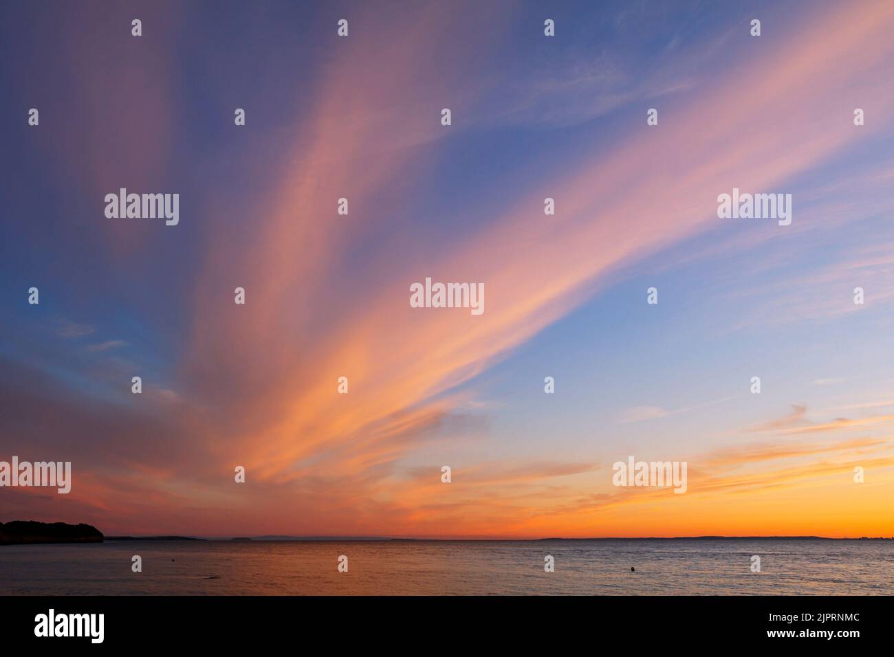The setting sun turning the cloud cover a pinkish hue Stock Photo - Alamy