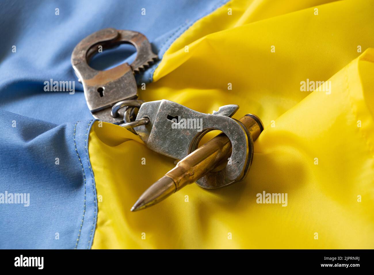 Handcuffs and a bullet lie on the yellow-blue flag of Ukraine, laws in ...