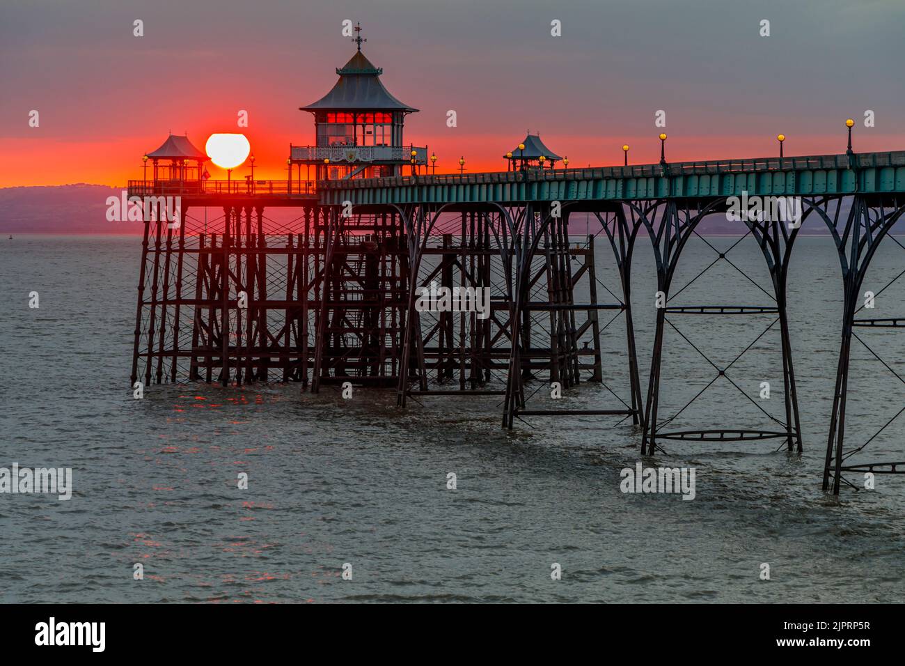 The sun setting behind the pier Stock Photo - Alamy