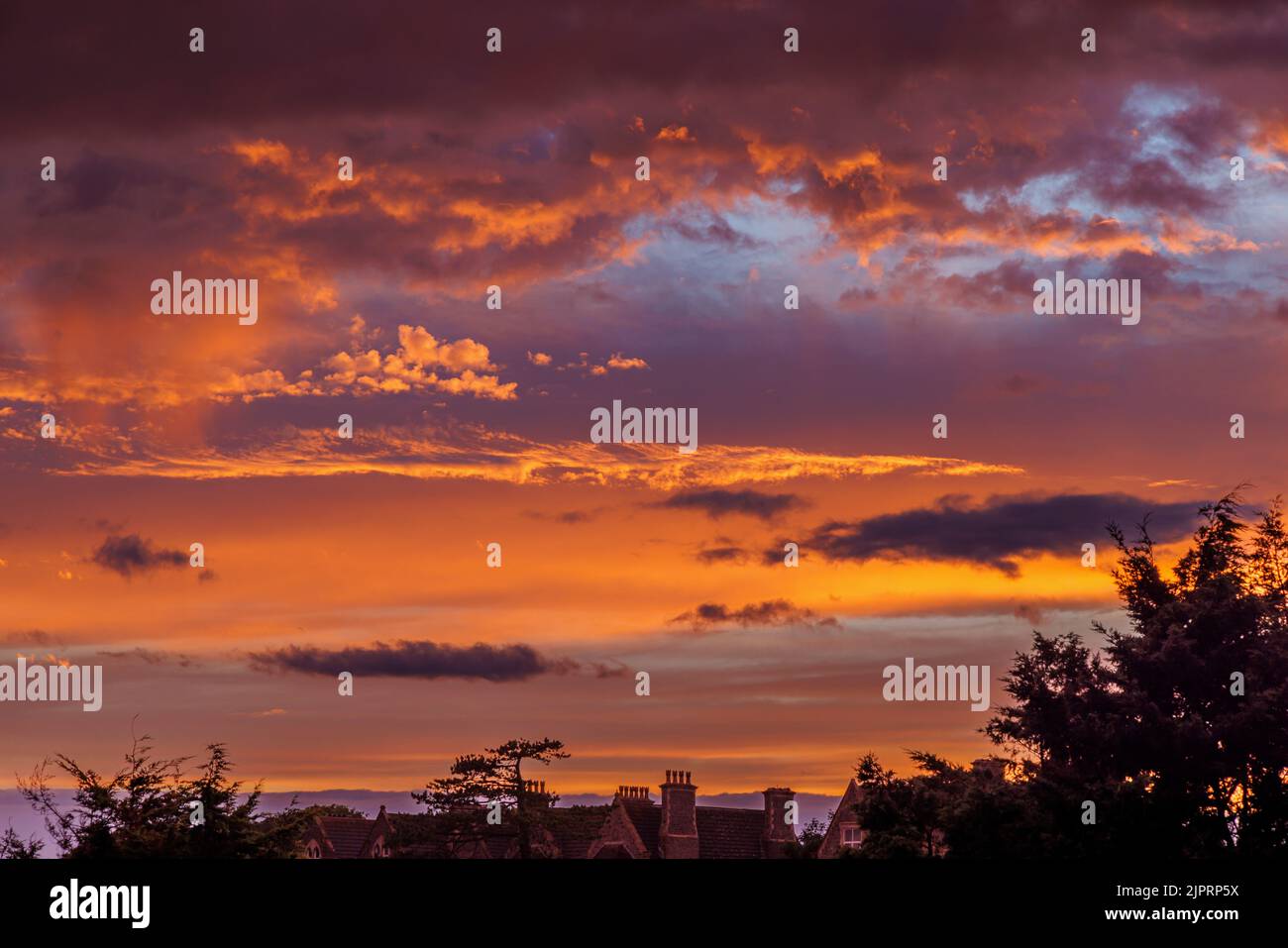 The setting sun lighting up the cloud cover Stock Photo - Alamy