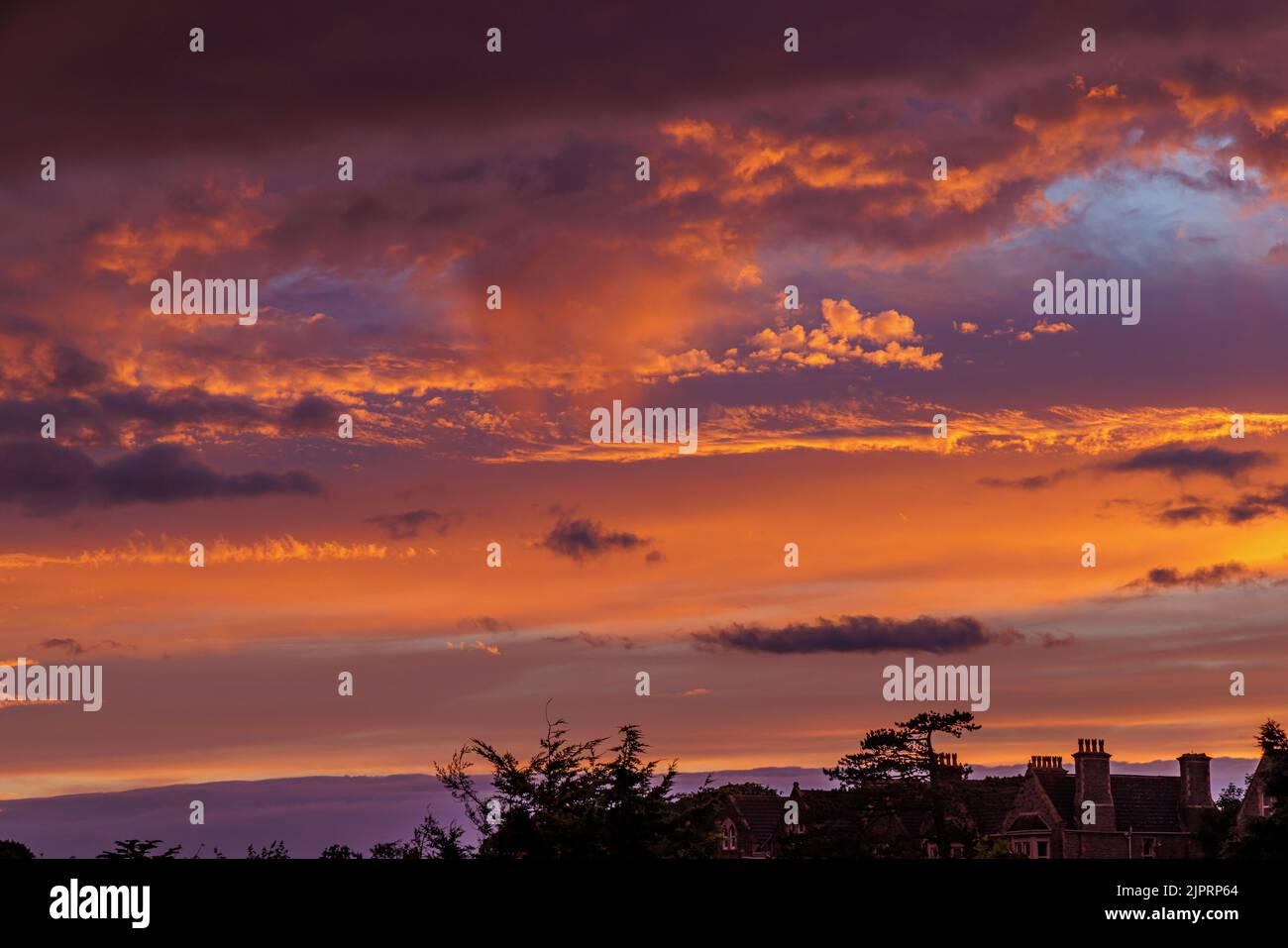 The setting sun lighting up the cloud cover Stock Photo - Alamy
