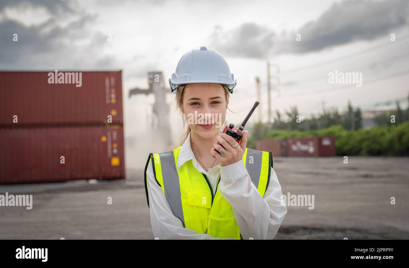 Woman foreman smile using walkie talkie in front of Cargo forklift in ...