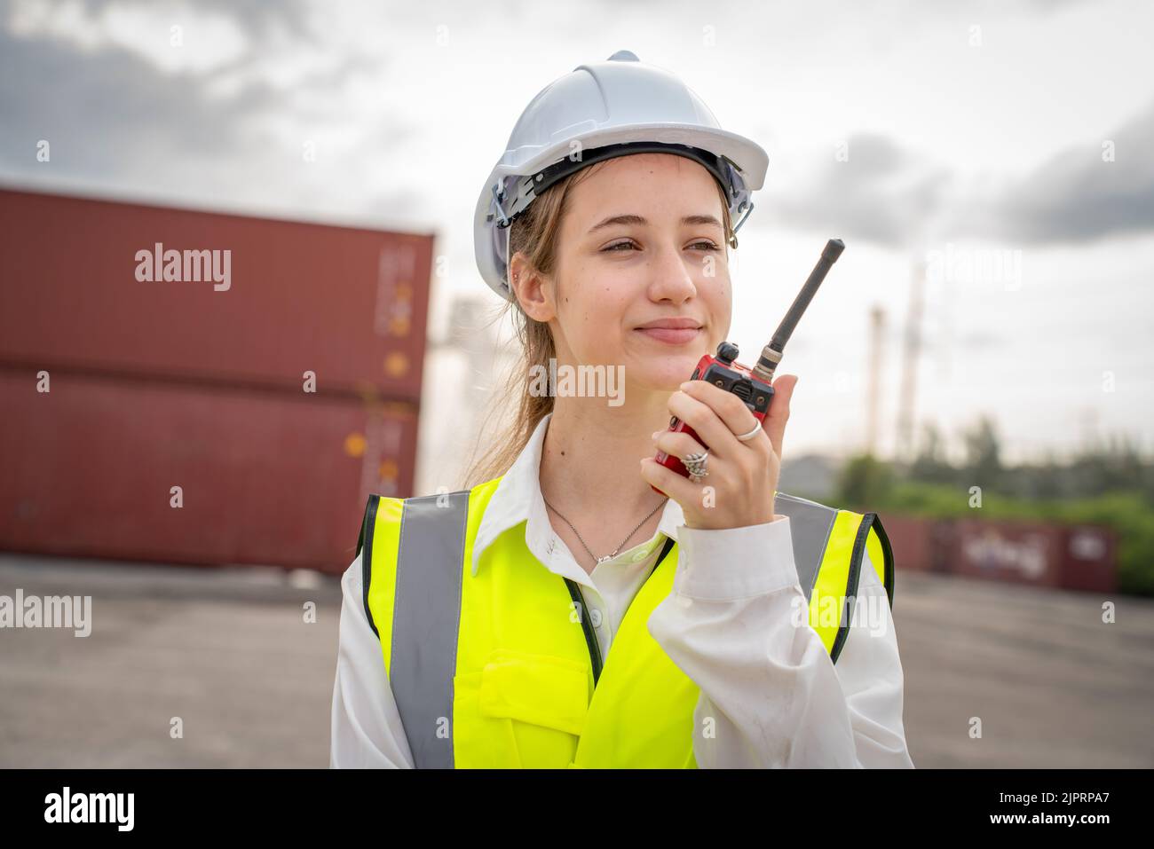 Woman foreman smile using walkie talkie in front of Cargo forklift in ...