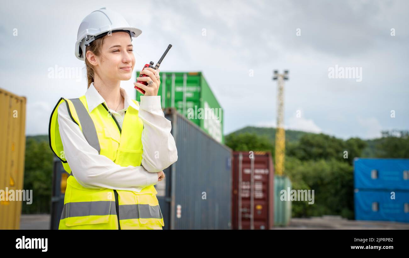 Woman foreman smile using walkie talkie in front of Cargo forklift in ...