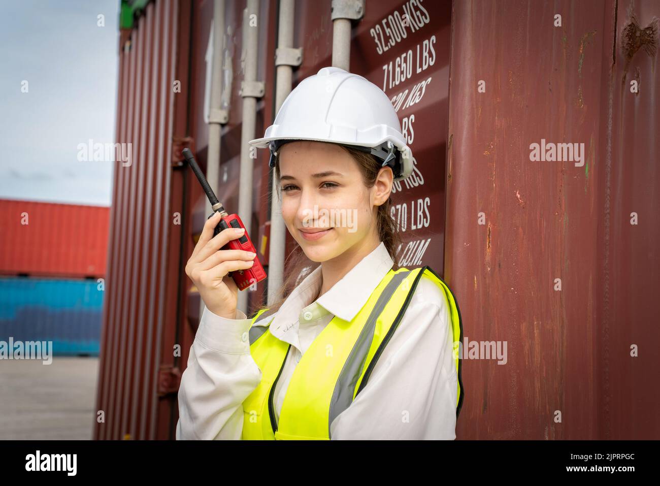 Woman foreman smile using walkie talkie in front of Cargo forklift in ...