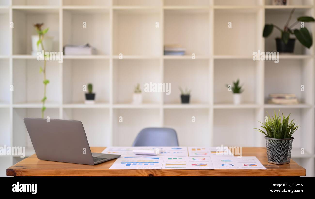 Comfortable home office, laptop, documents and houseplant on wooden ...