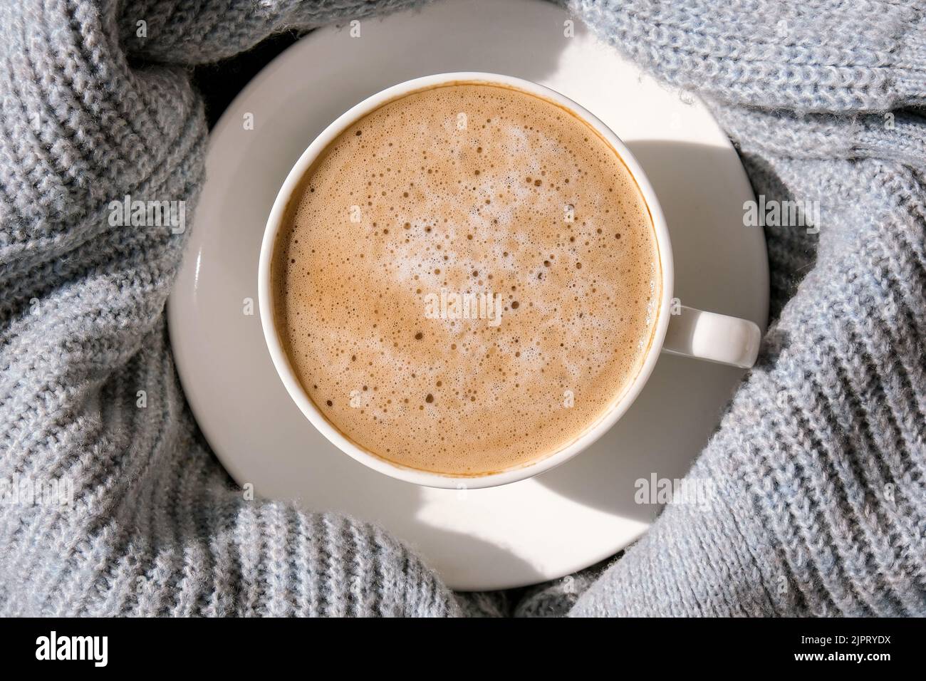 White cup of morning coffee on blue sweater background. Cozy home ...