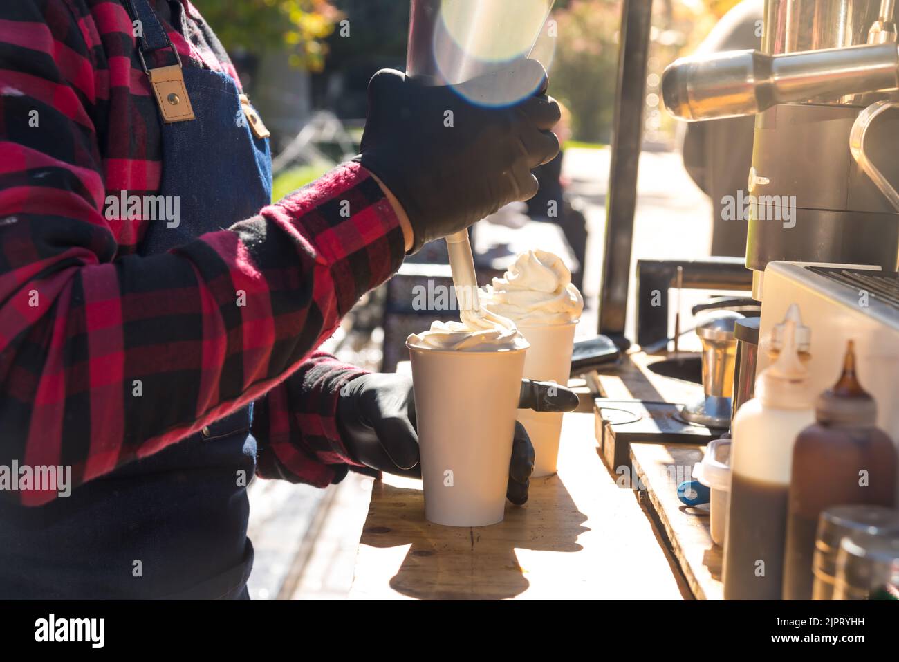 A barista adding cream to coffee Stock Photo - Alamy