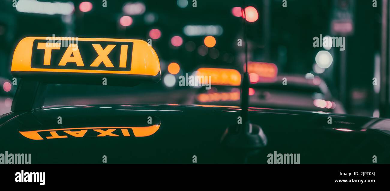 A selective focus of a taxi sign with a night city view in the ...