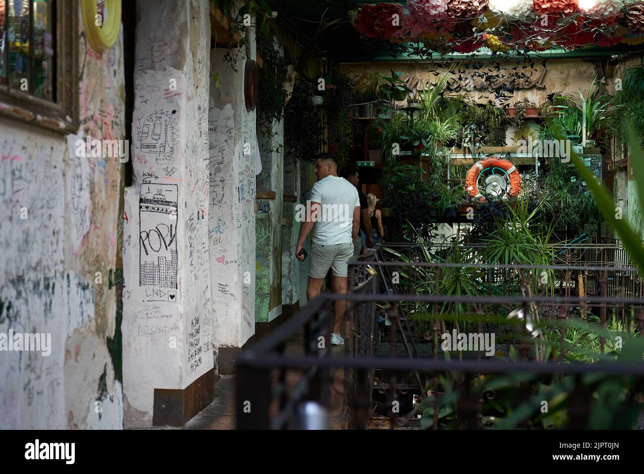 Men walks inside the Budapest pub ruins. Hungary, Budapest, July 20 ...
