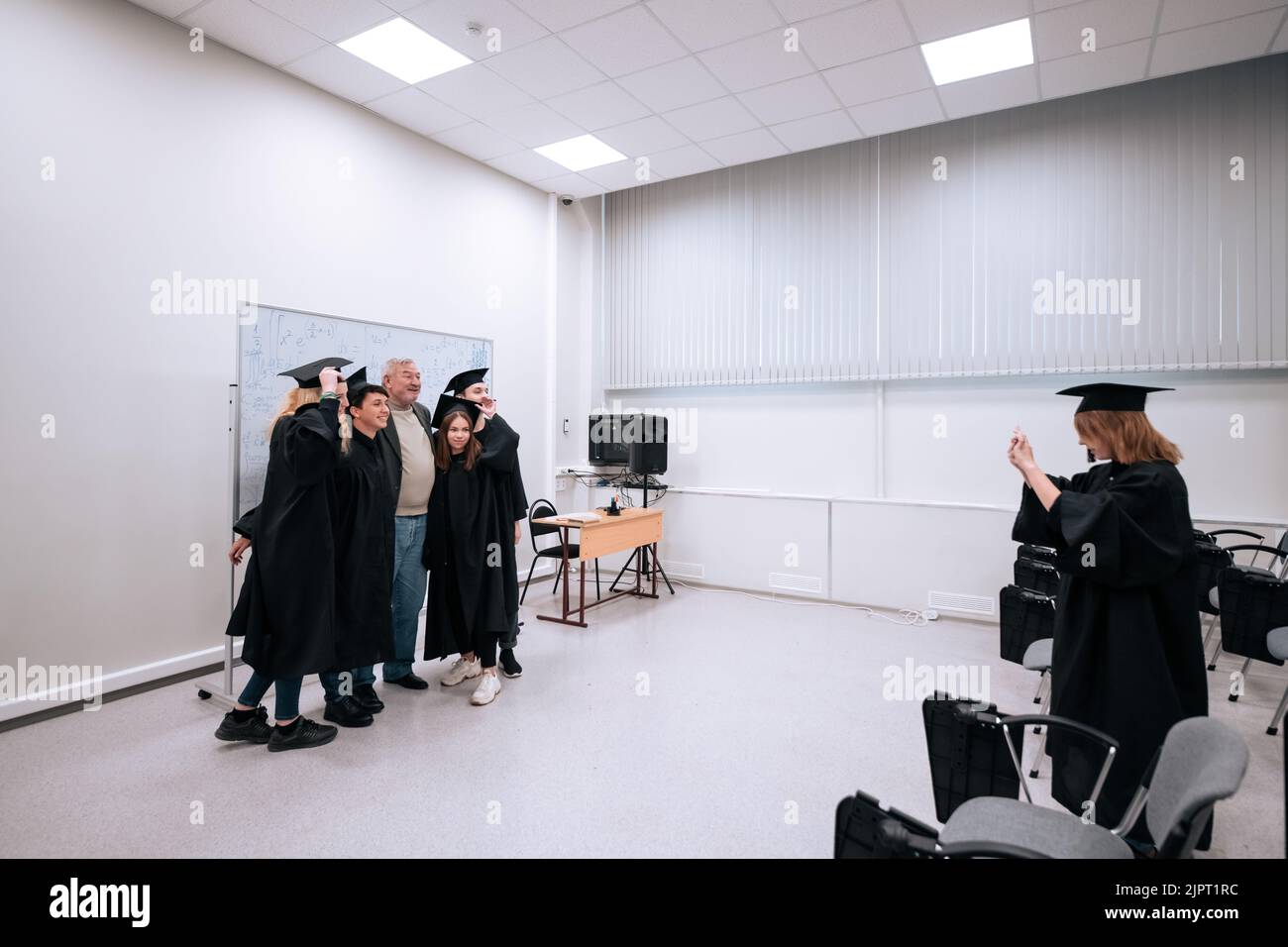 At the graduation party, young graduates in robes together with their ...