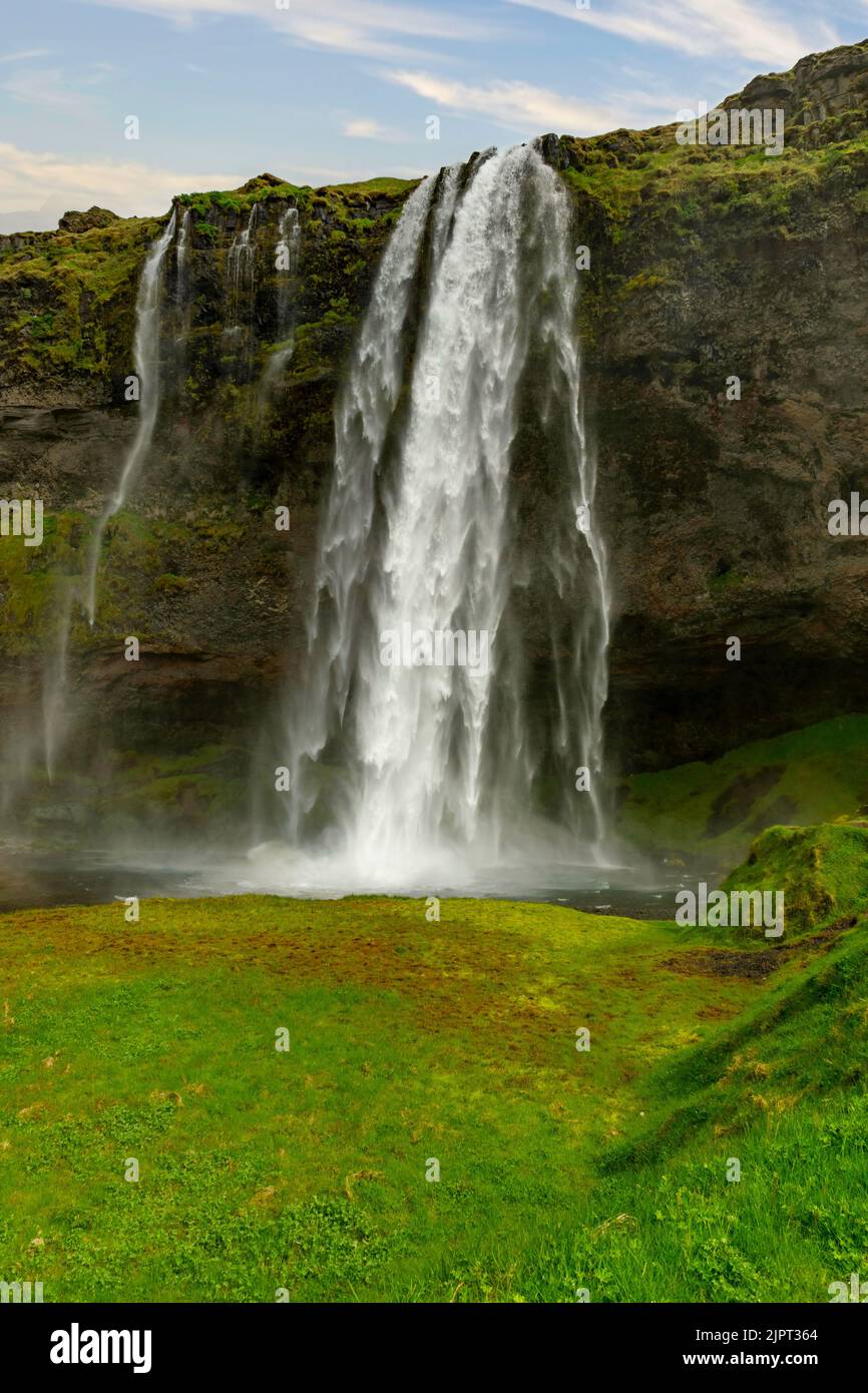 A vertical shot of the Seljalandsfoss waterfall in Iceland cascading ...