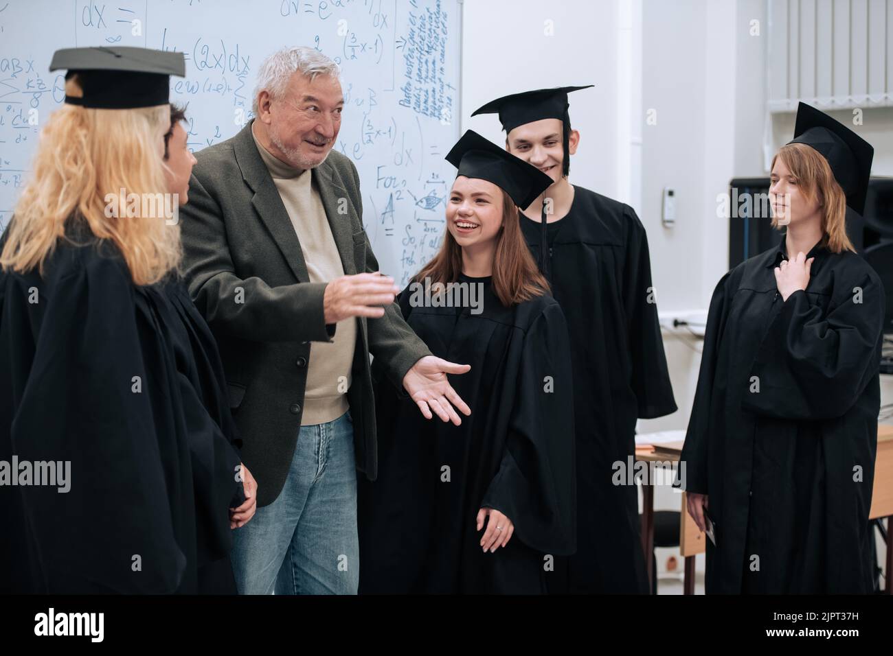 In the math class, an elderly gray-haired professor congratulates ...