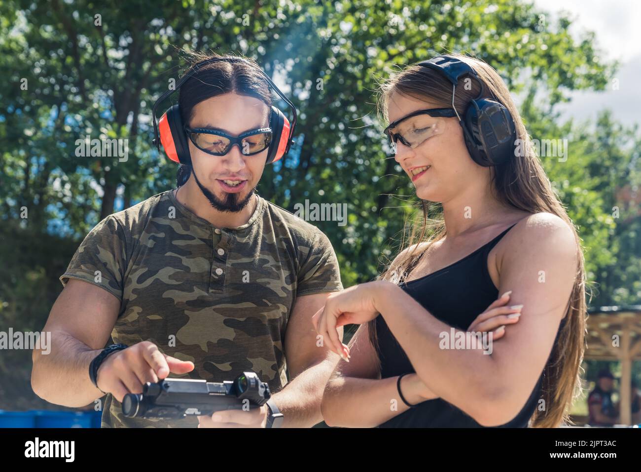 White man and woman wearing safety goggles and headphones talking about ...
