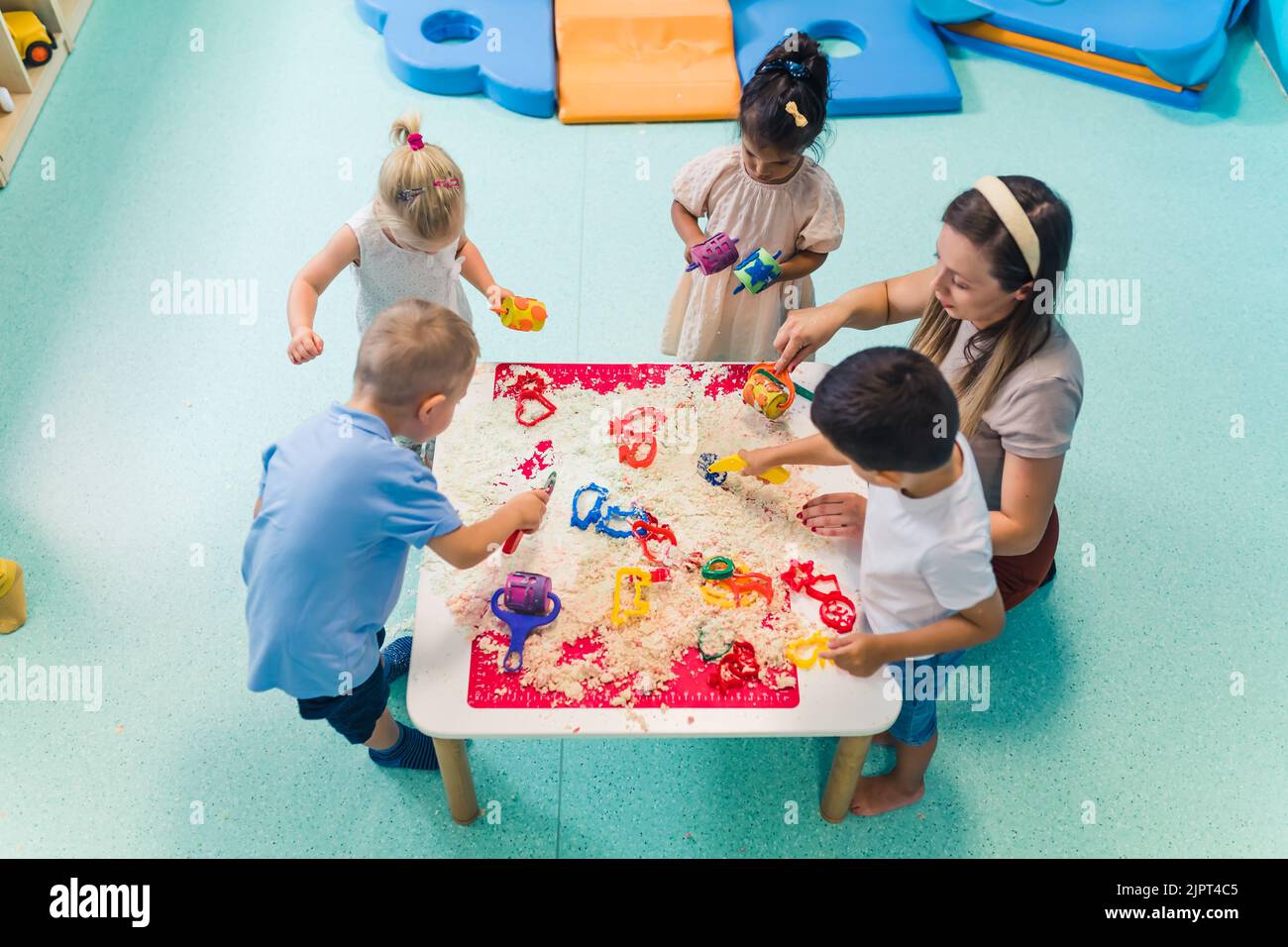 calming sensory play at nursery school. Toddlers with their teacher ...