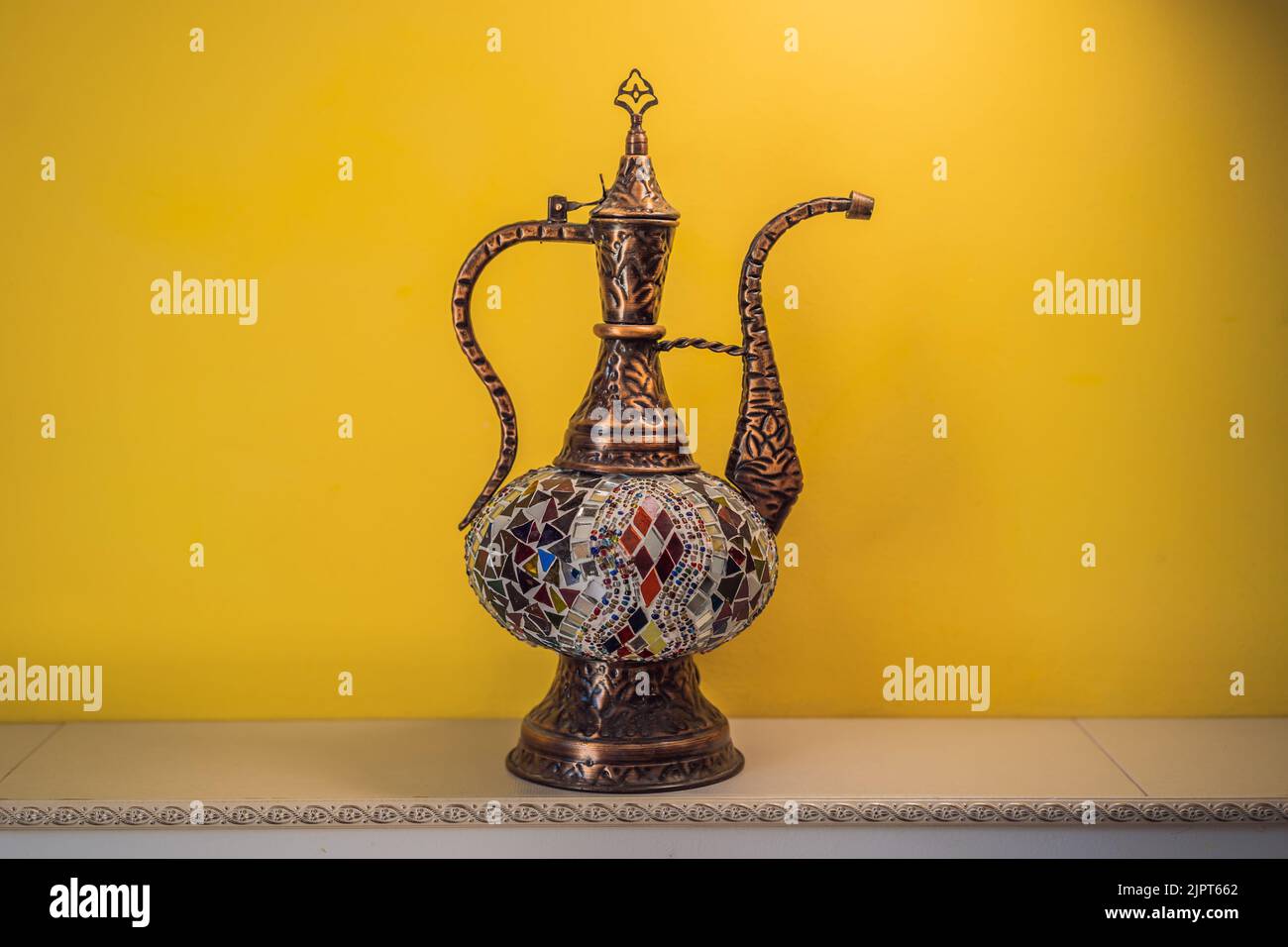 Traditional Moroccan earthenware pottery jug standing against the brown ...