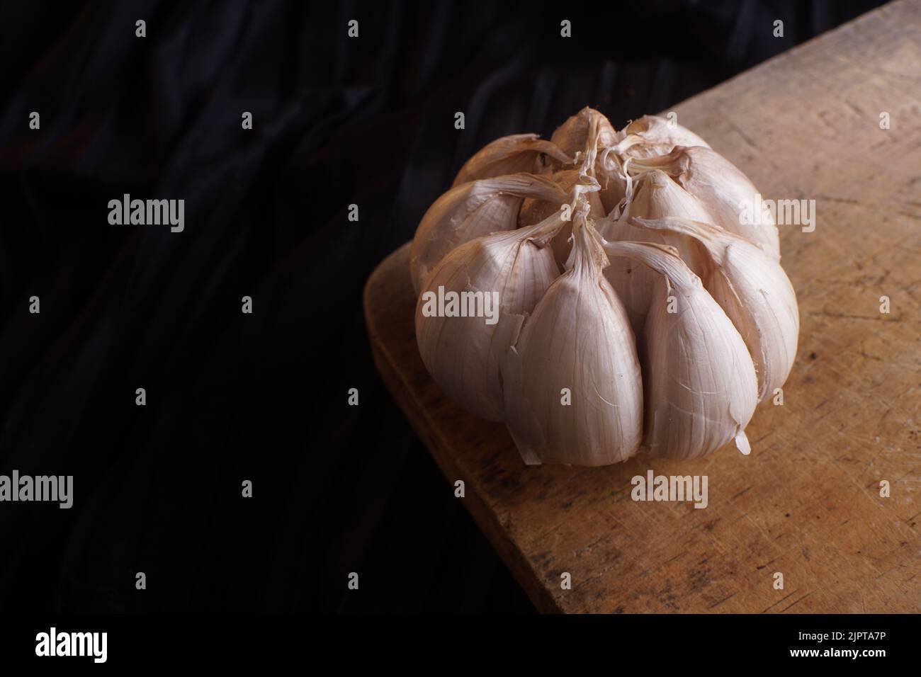Garlic one bud with a black background texture Stock Photo - Alamy