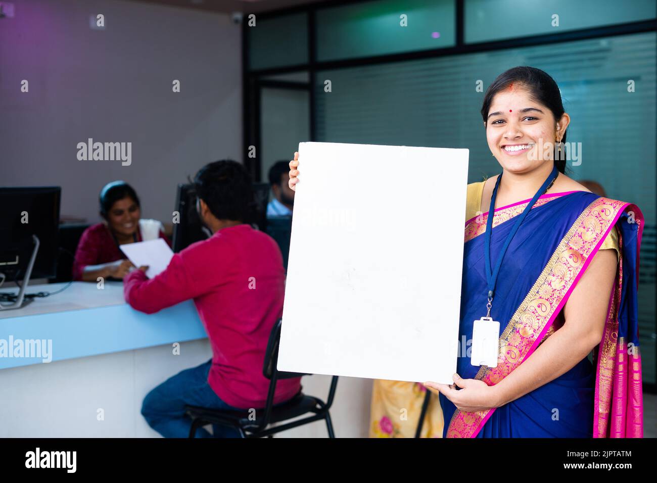Happy smiling banker showing white empty board or sign board by looking ...