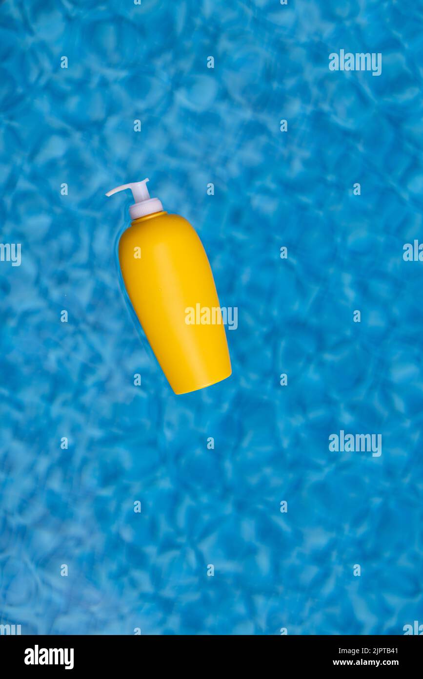Sunscreen bottle floating in blue water of swimming pool Stock Photo ...