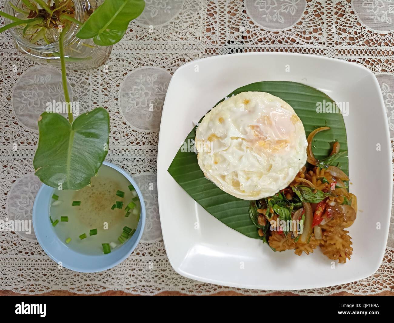 fried egg with stir fry squid cuttlefish chilli basil leaves. Thai food ...