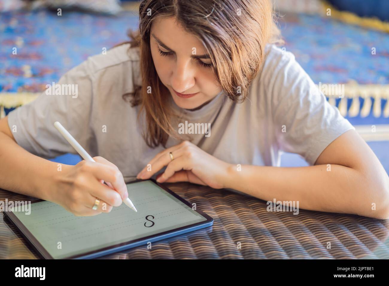 Calligrapher Young Woman writes phrase on digital tablet. Inscribing ...