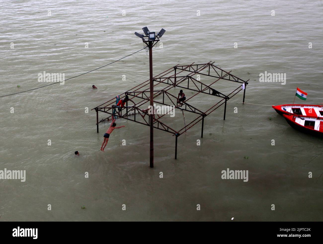 Prayagraj, India. 20/08/2022, A boy jumps in to the river ganges from a ...