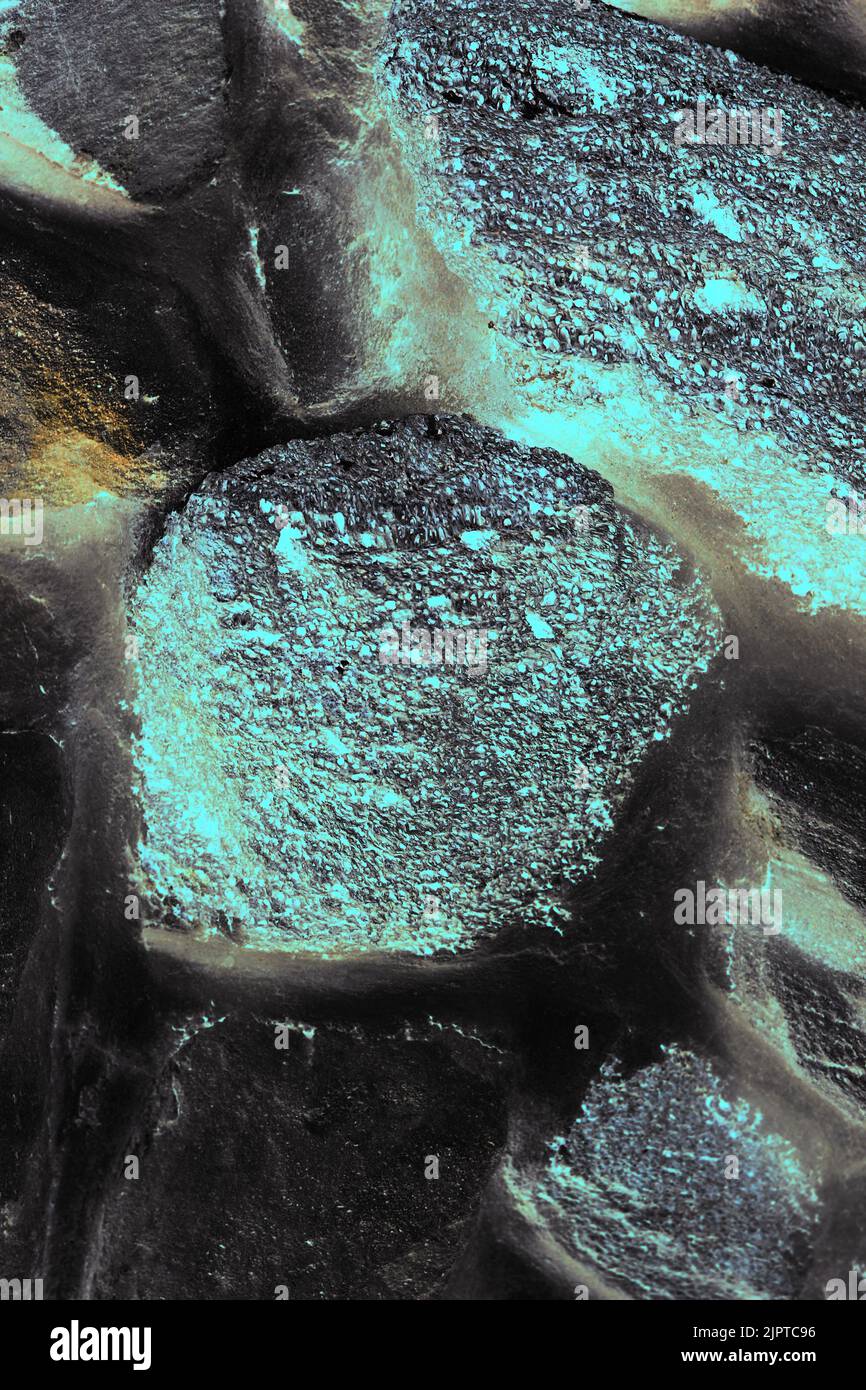 A lava rock set inside a natural stone wall in a neon blue color ...