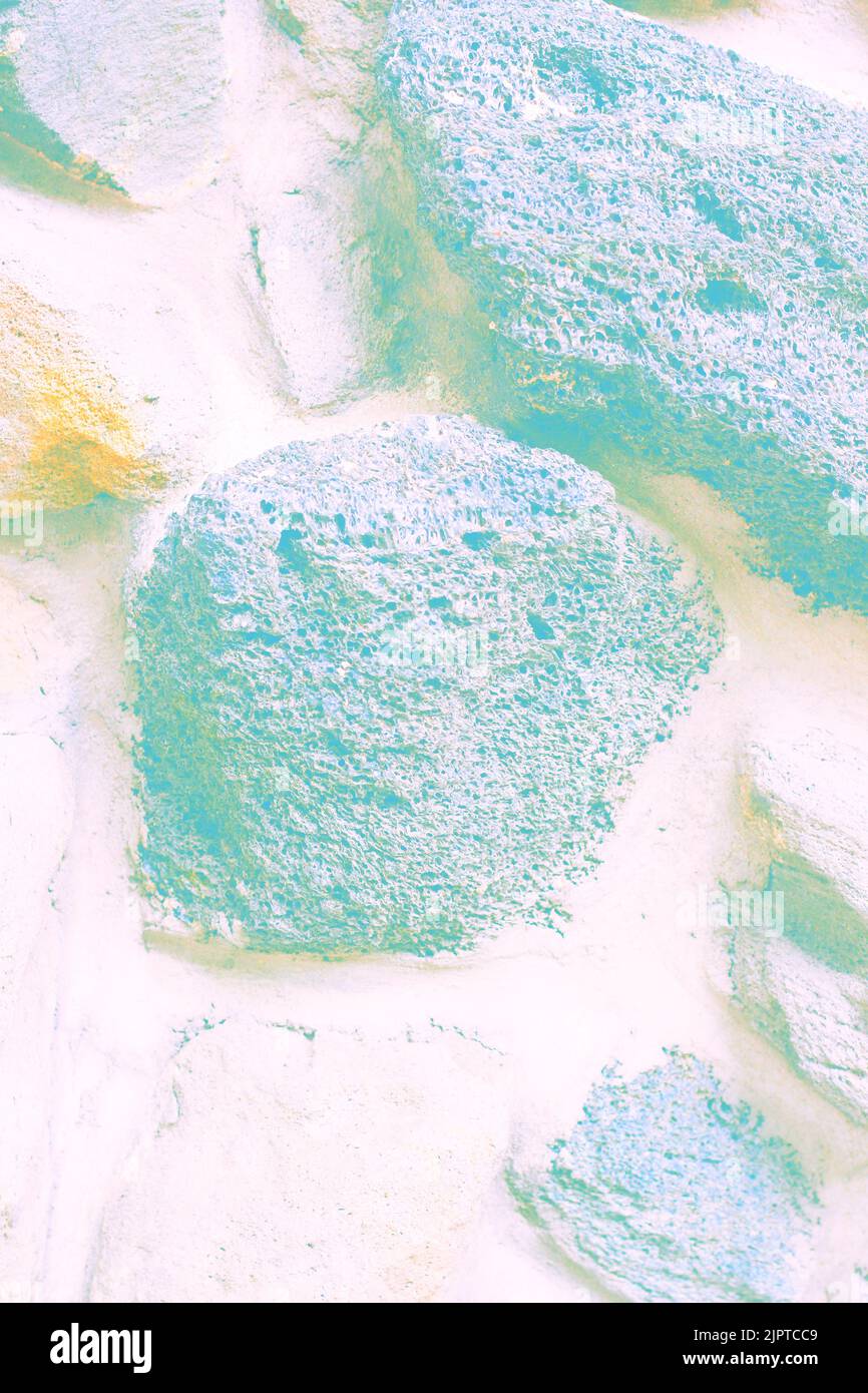 A lava rock set inside a natural stone wall in a faded neon blue color ...