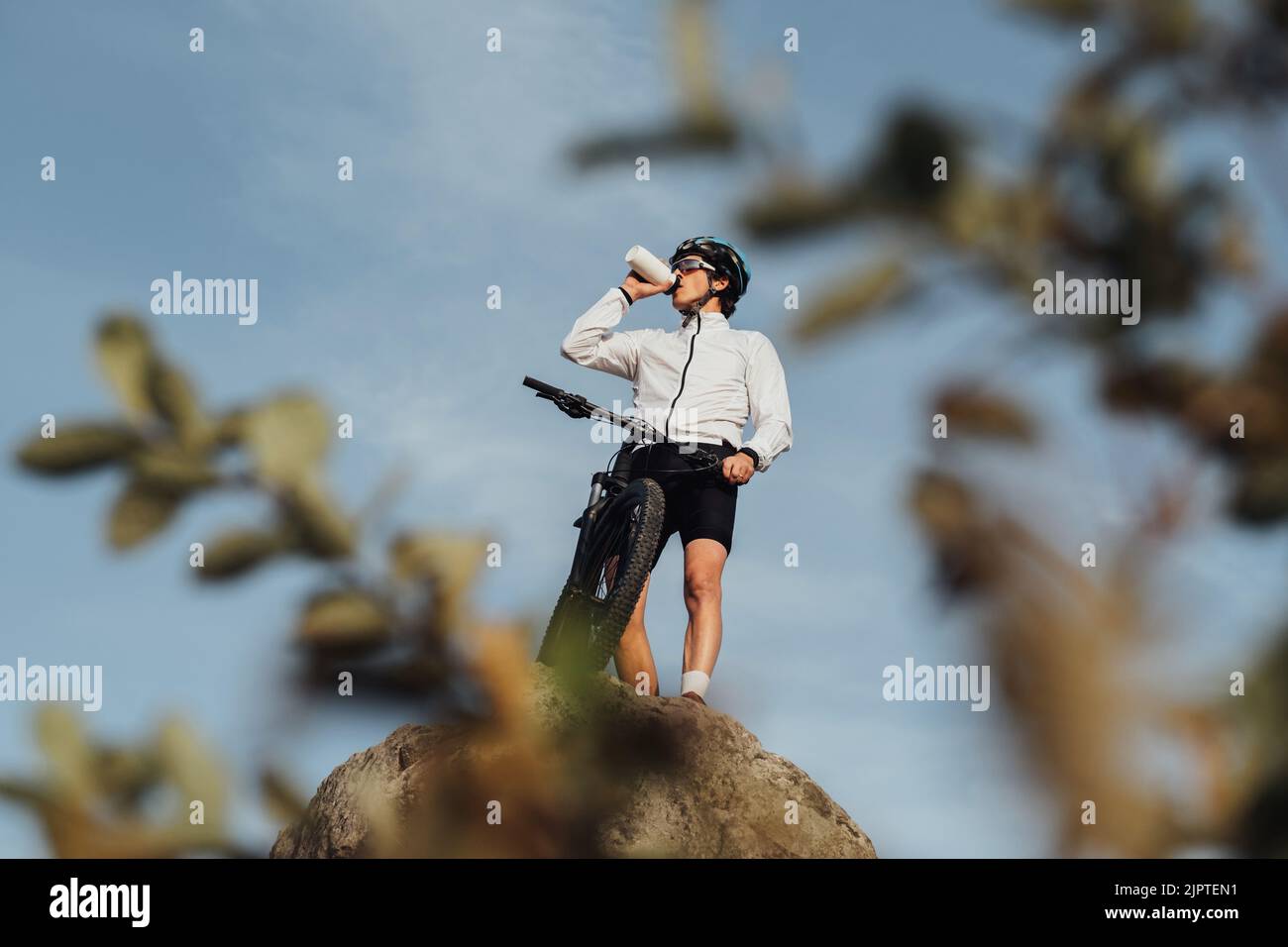 Professional Male Cyclist Drinking Water from Bottle while Standing ...