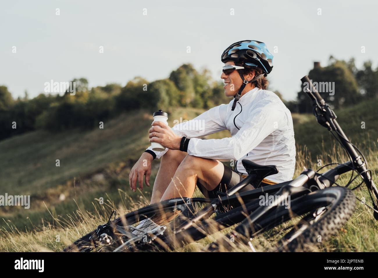 Professional Male Cyclist Drinking Water from Bottle, Man Sitting Near ...